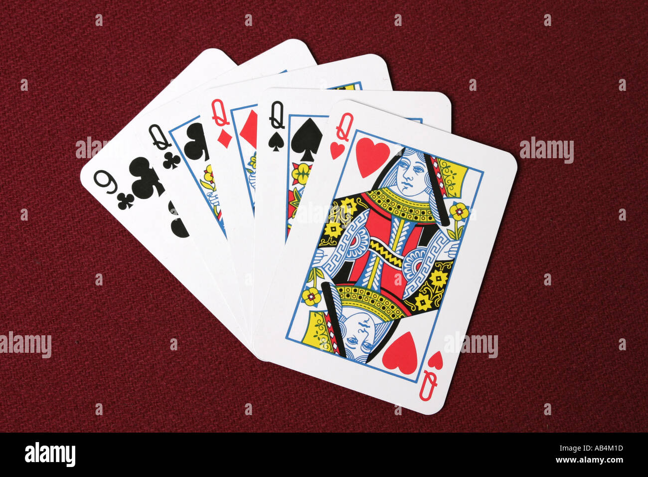 Four of a kind poker hand cards fanned out on a red dealers table Stock ...