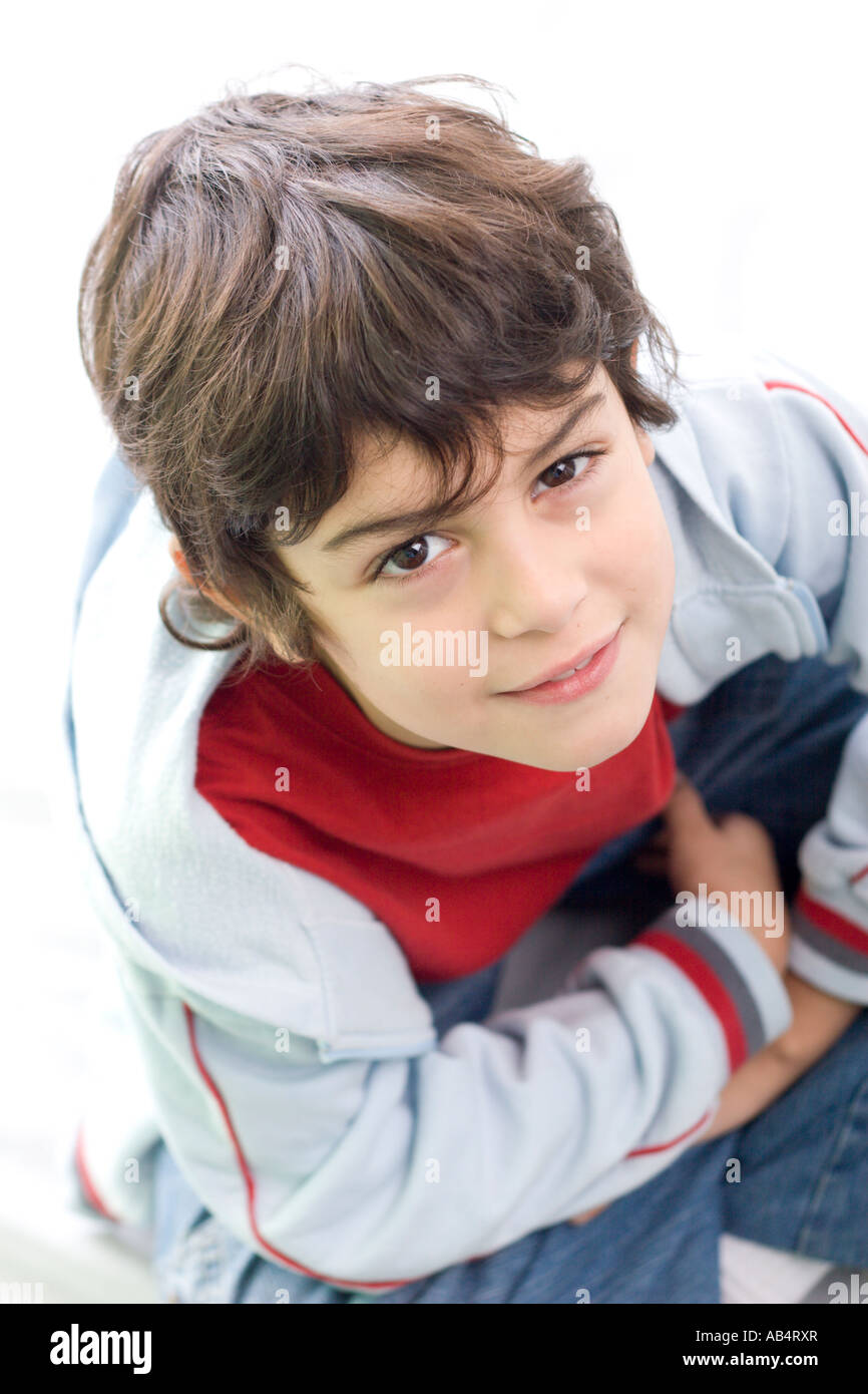 Ten year old boy looking up and sit down Stock Photo - Alamy