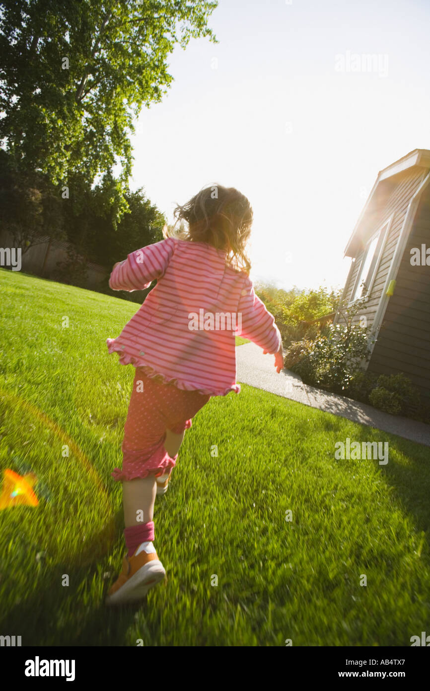 Back of girl running in back yard Stock Photo - Alamy