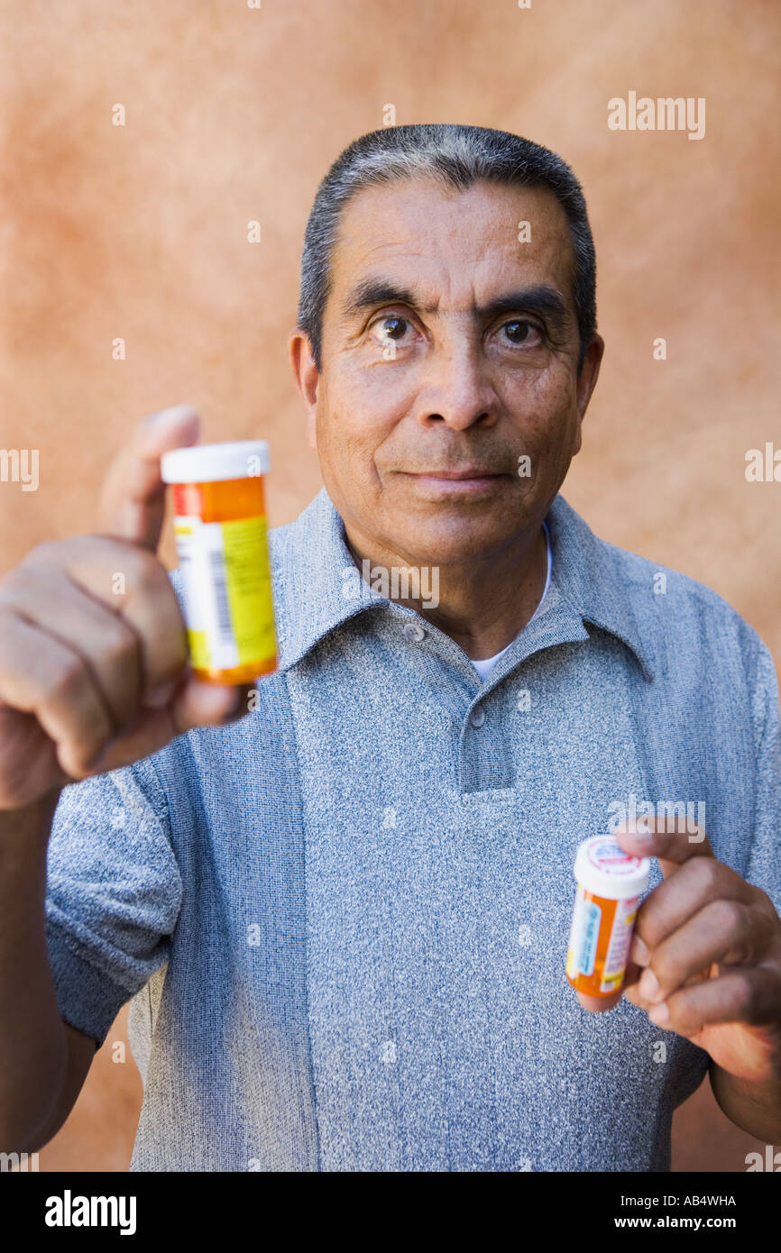 Portrait of man holding medication bottles Stock Photo - Alamy
