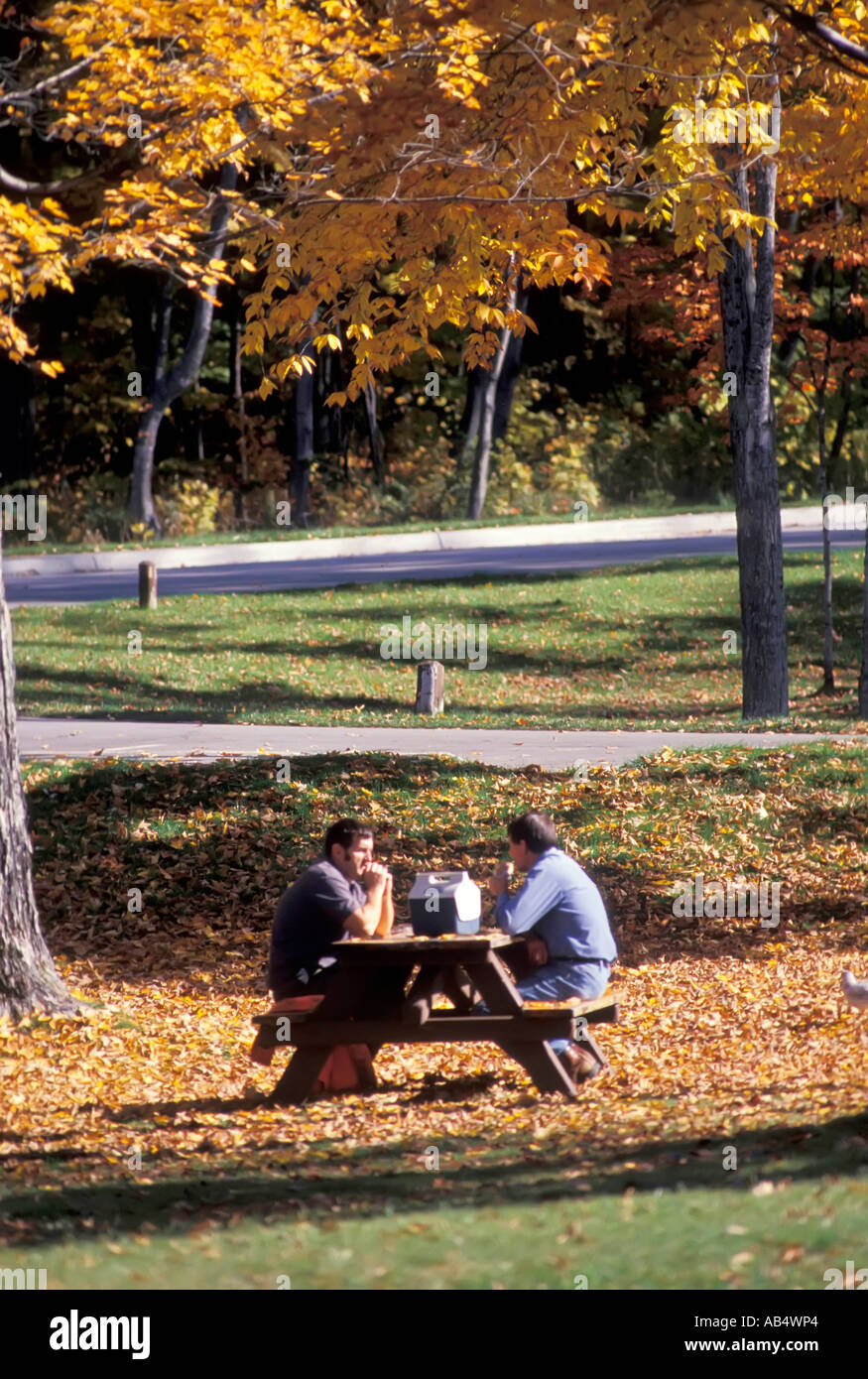 Two men eat during a lunch break during fall color time in Michigan ...