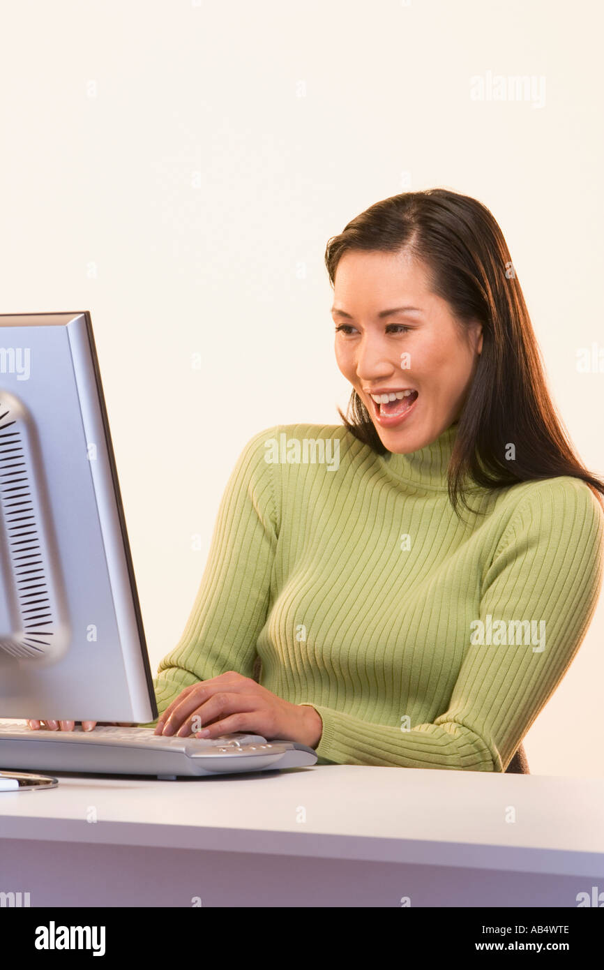 Businesswoman laughing while typing at computer Stock Photo - Alamy