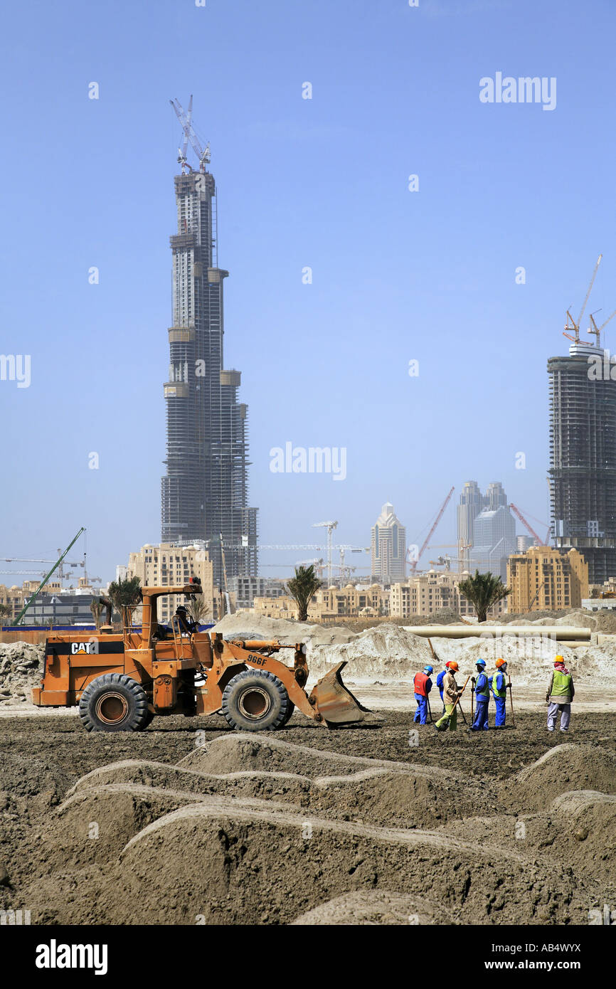 small group of men working in construction site with Burj Dubai tower ...