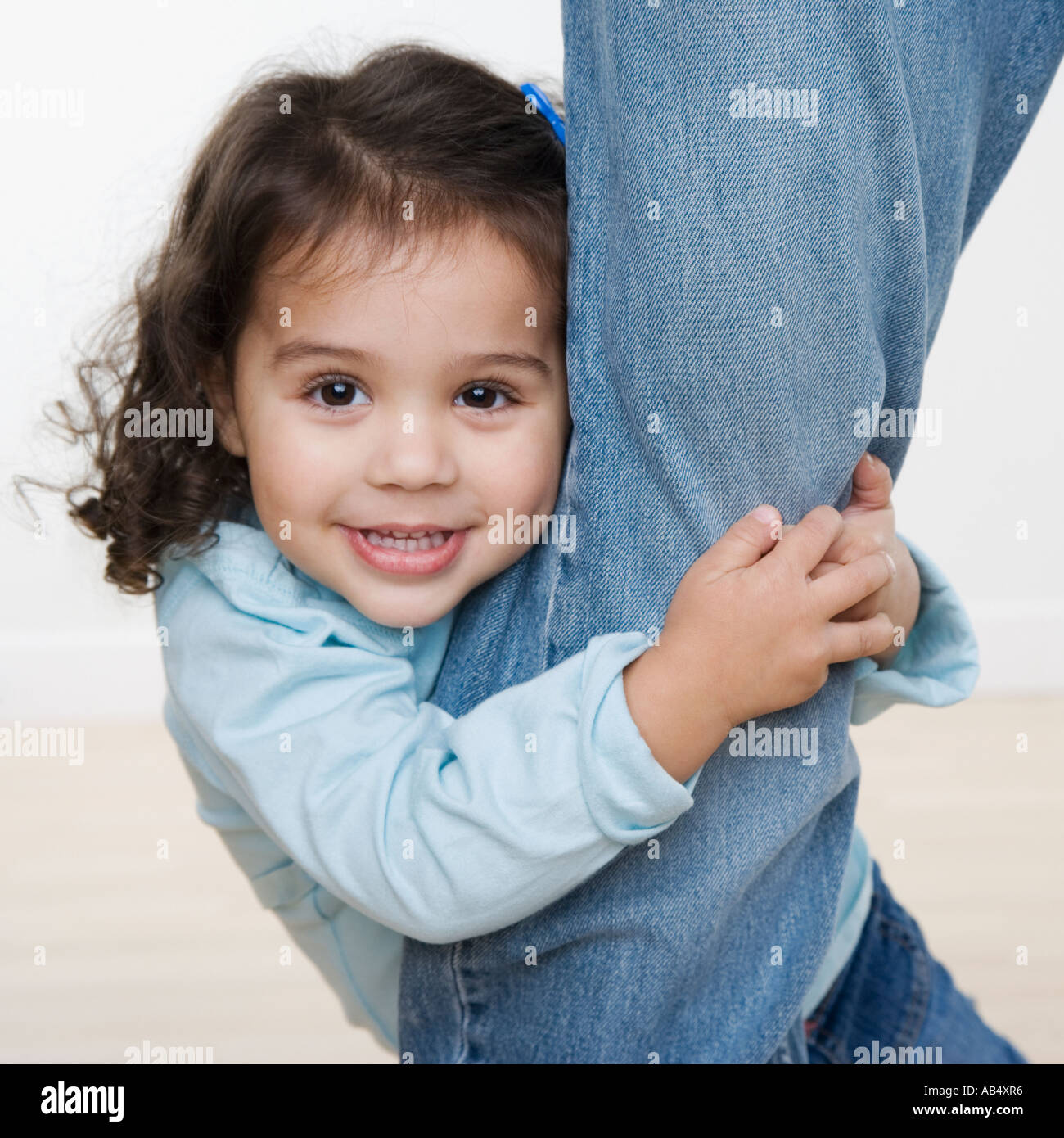 Portrait of young girl hugging leg of mother Stock Photo - Alamy