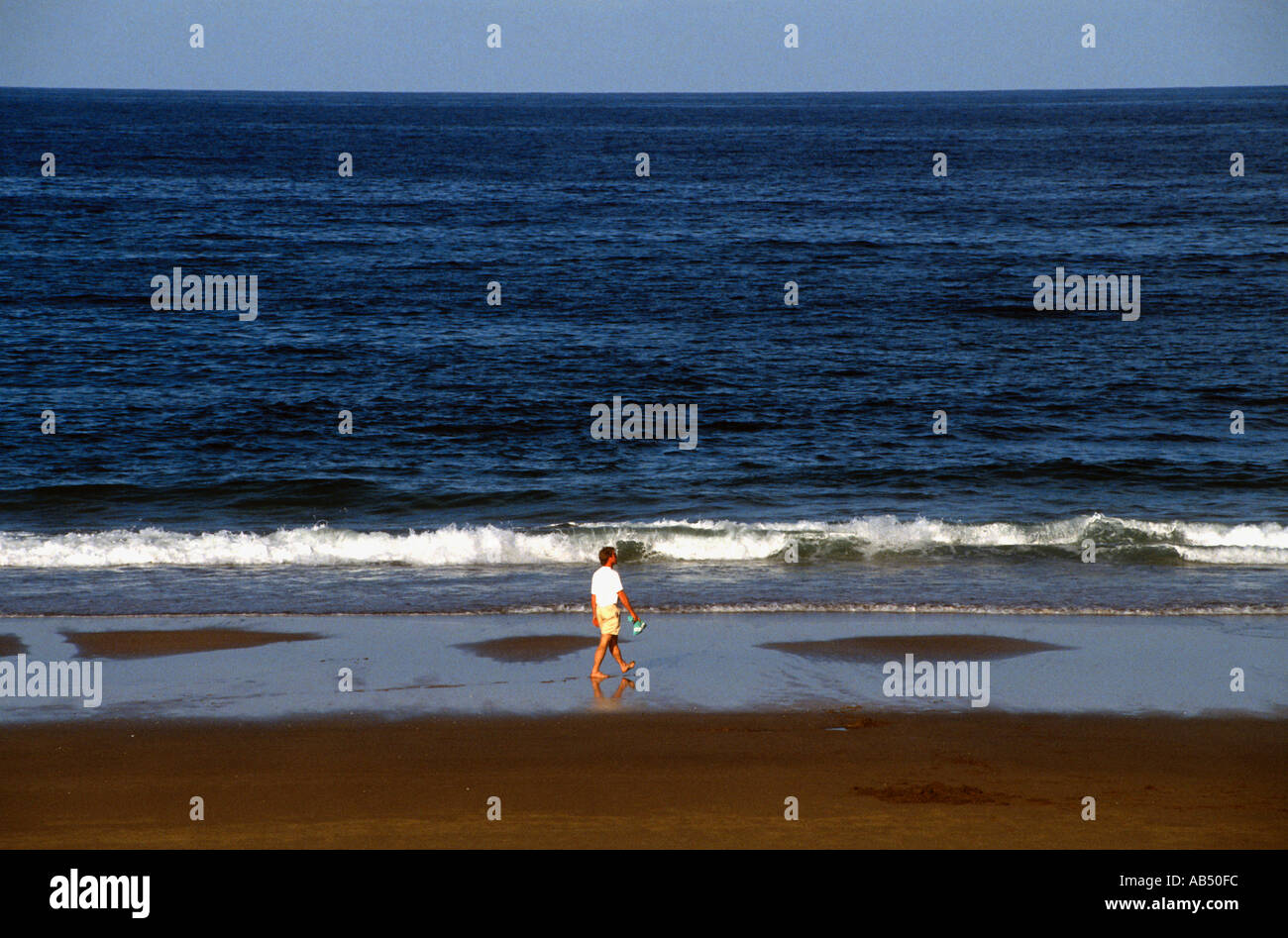 November 1989 New Zealand Man walking on beach Stock Photo - Alamy