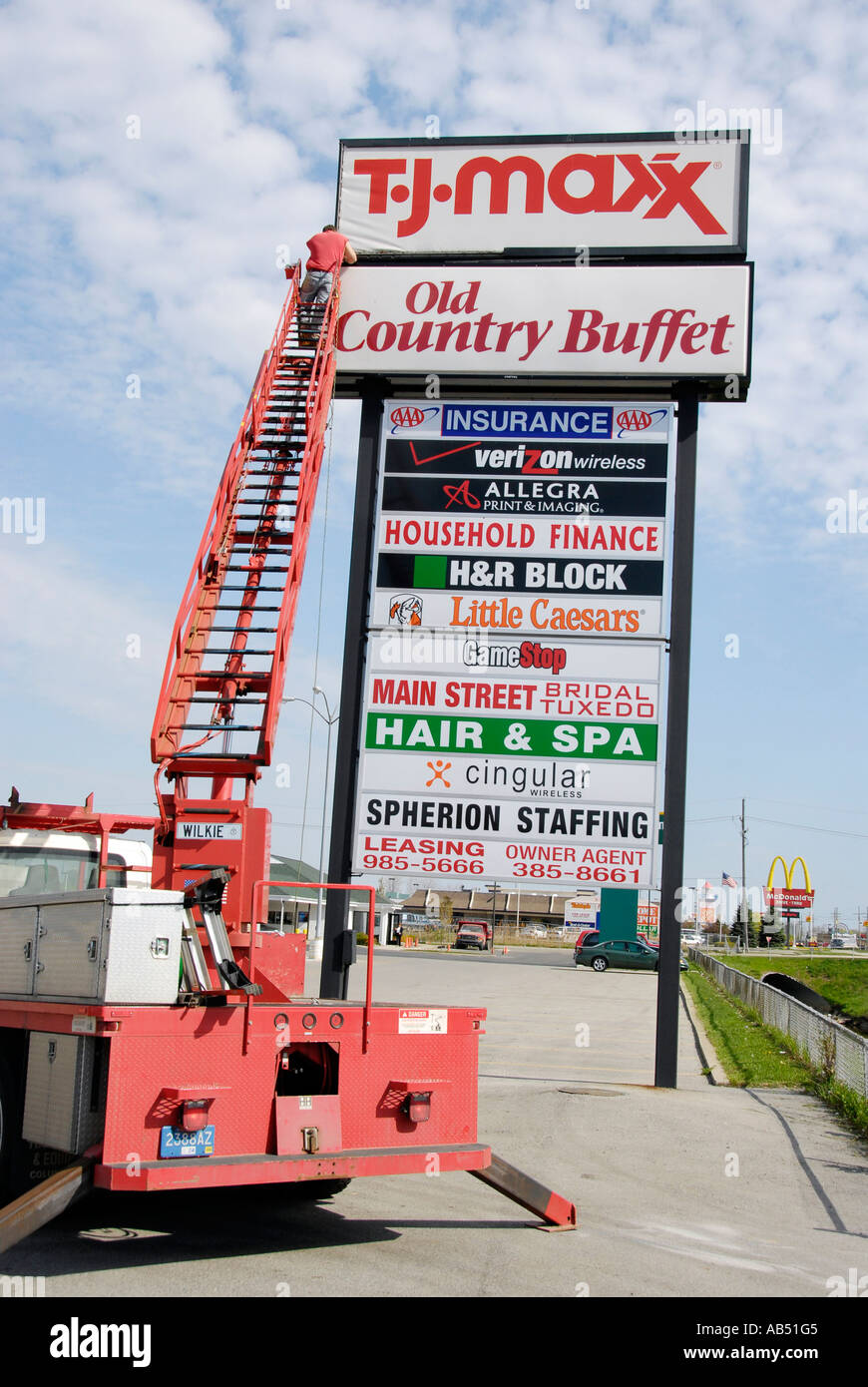 Maintenance crew works to restore fix and refurbish an advertising sign ...