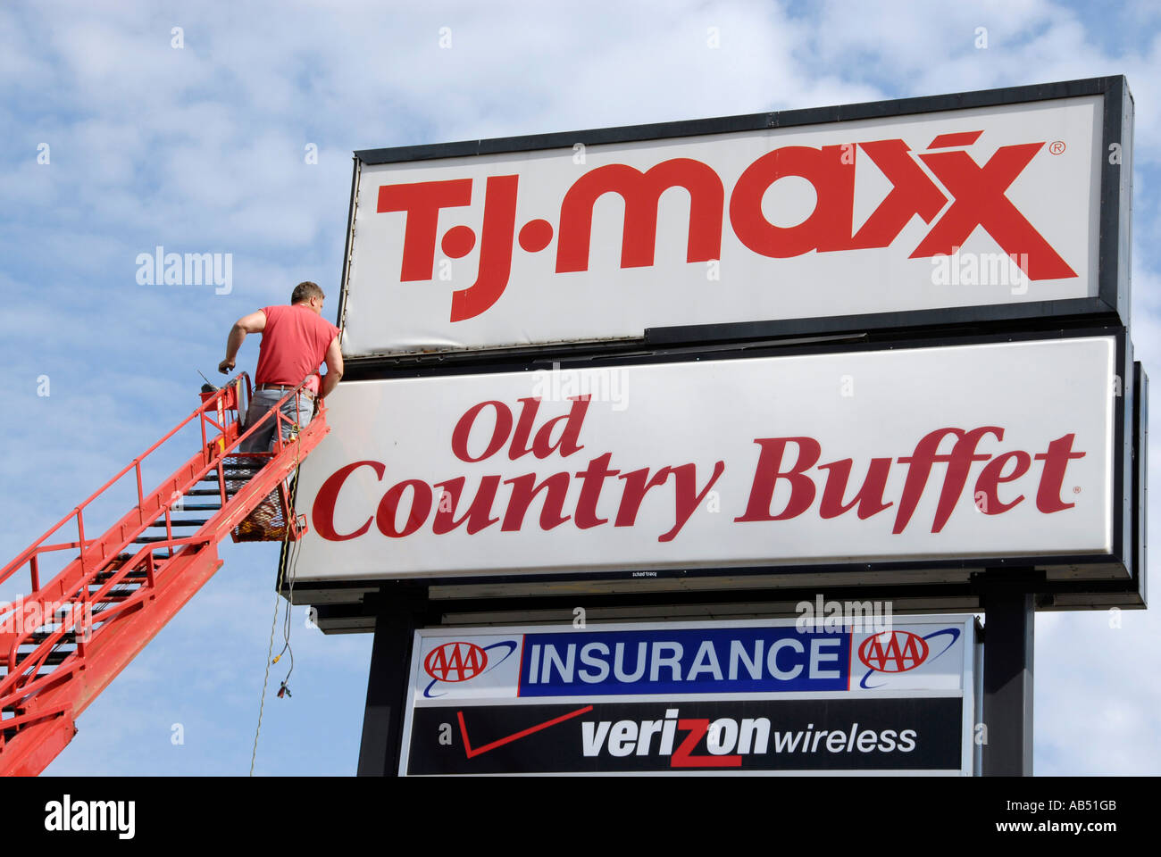 Maintenance crew works to restore fix and refurbish an advertising sign ...