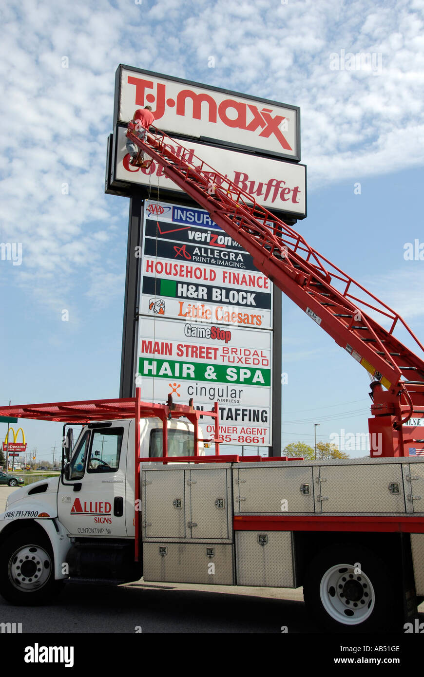 Maintenance crew works to restore fix and refurbish an advertising sign ...
