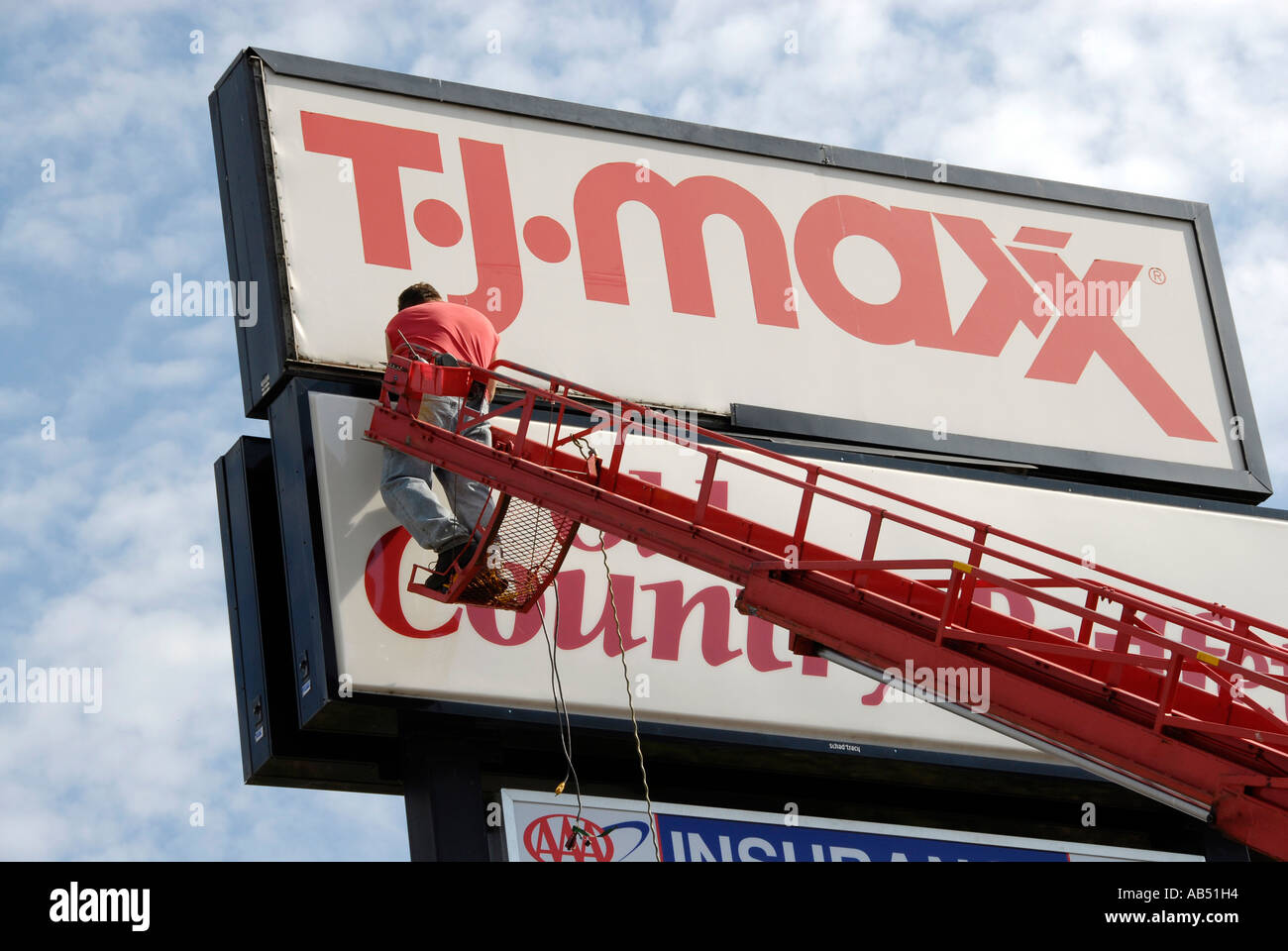 Maintenance crew works to restore fix and refurbish an advertising sign ...