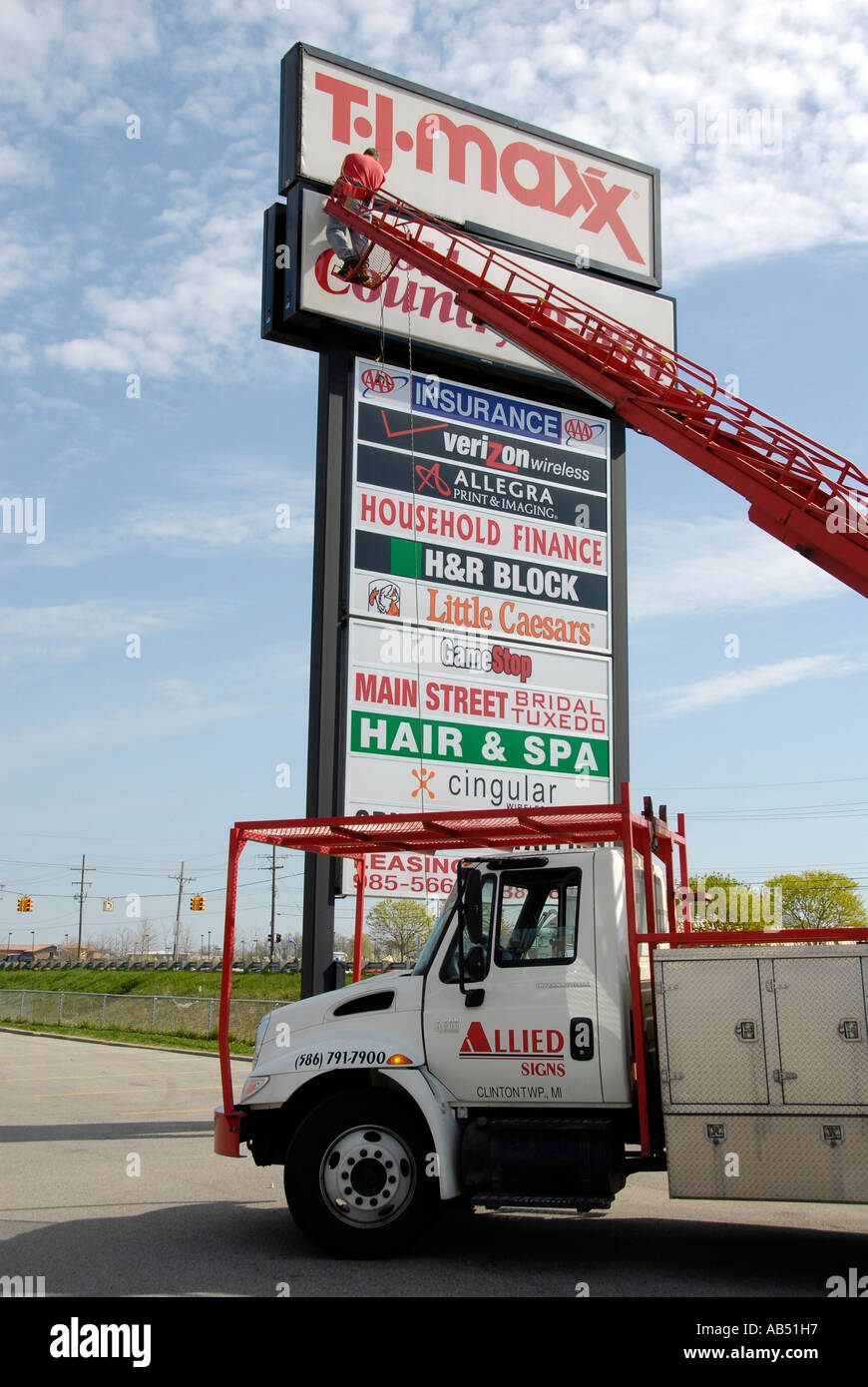 Maintenance crew works to restore fix and refurbish an advertising sign ...