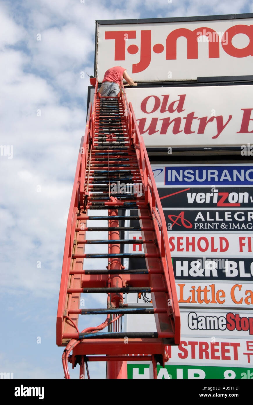 Maintenance crew works to restore fix and refurbish an advertising sign ...