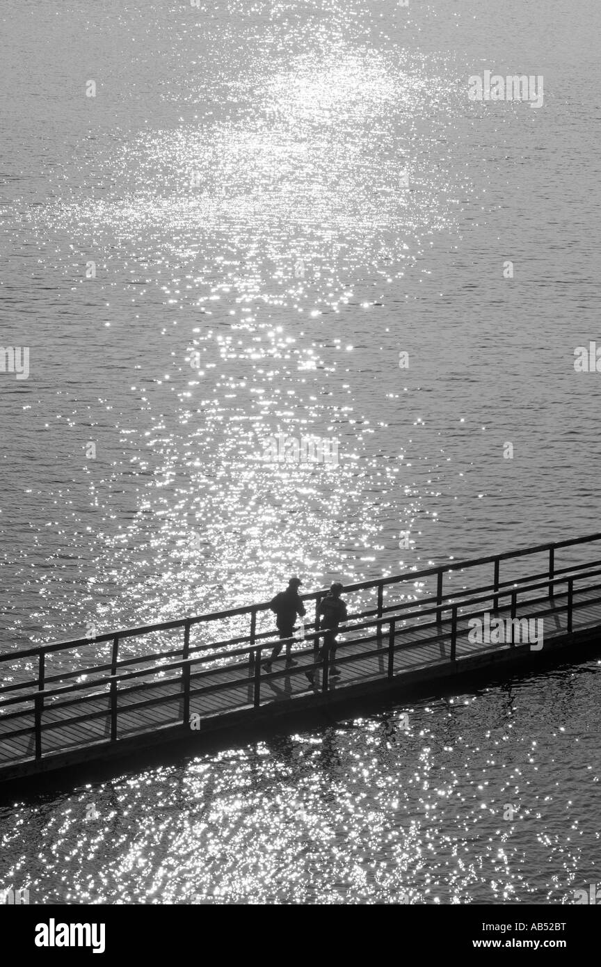 Two people running on bridge over water, high angle Stock Photo - Alamy