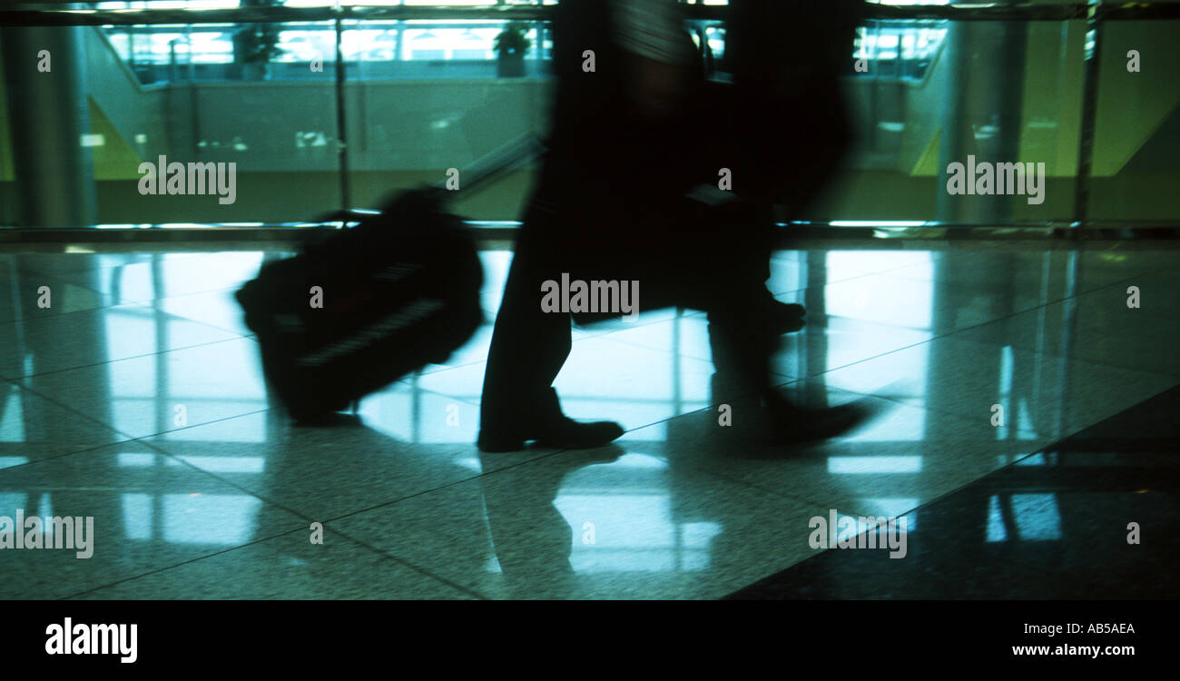 Passenger pulling small hand luggage case in departure lounge Dubai ...