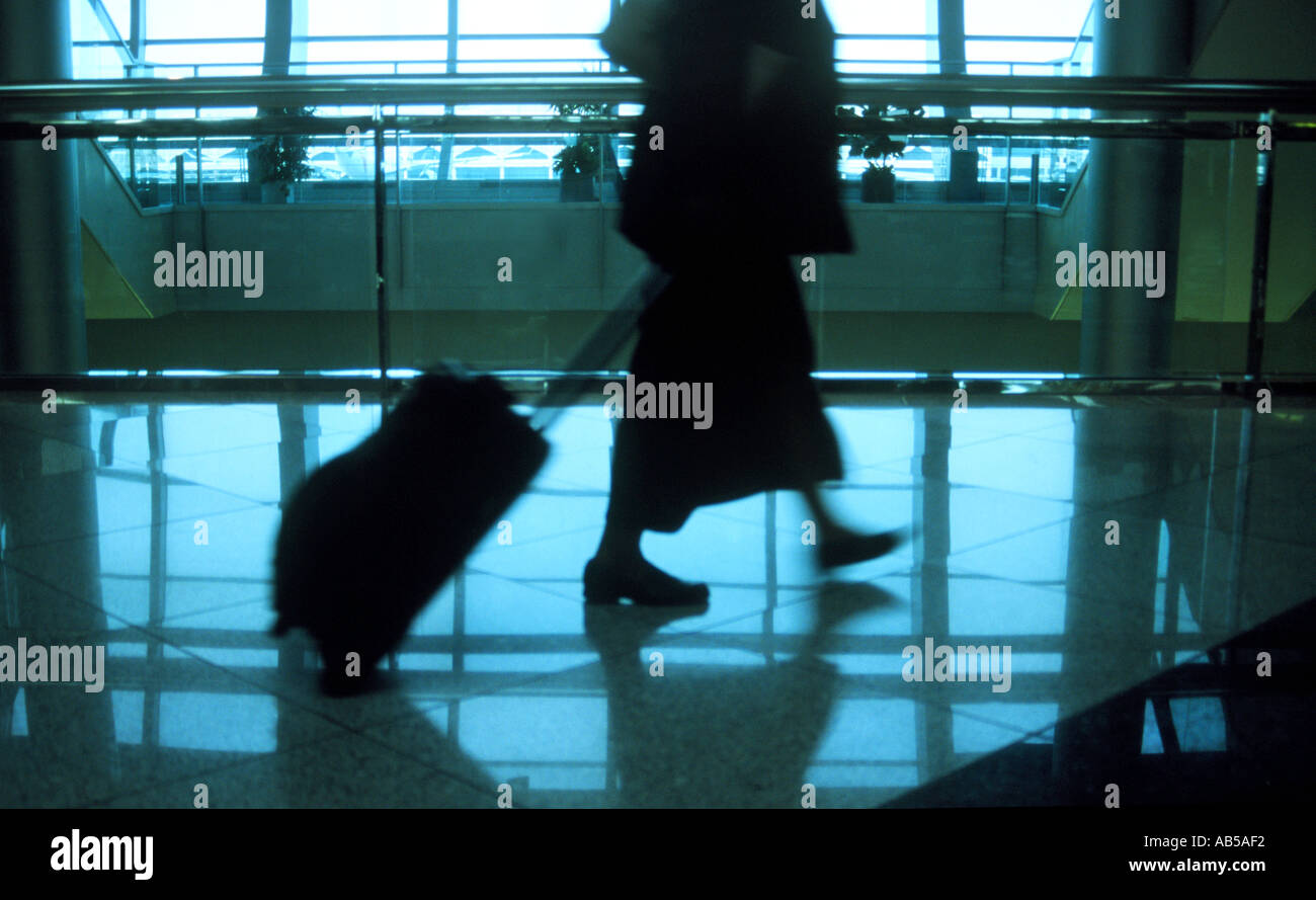 Passenger pulling small hand luggage case in departure lounge Dubai ...