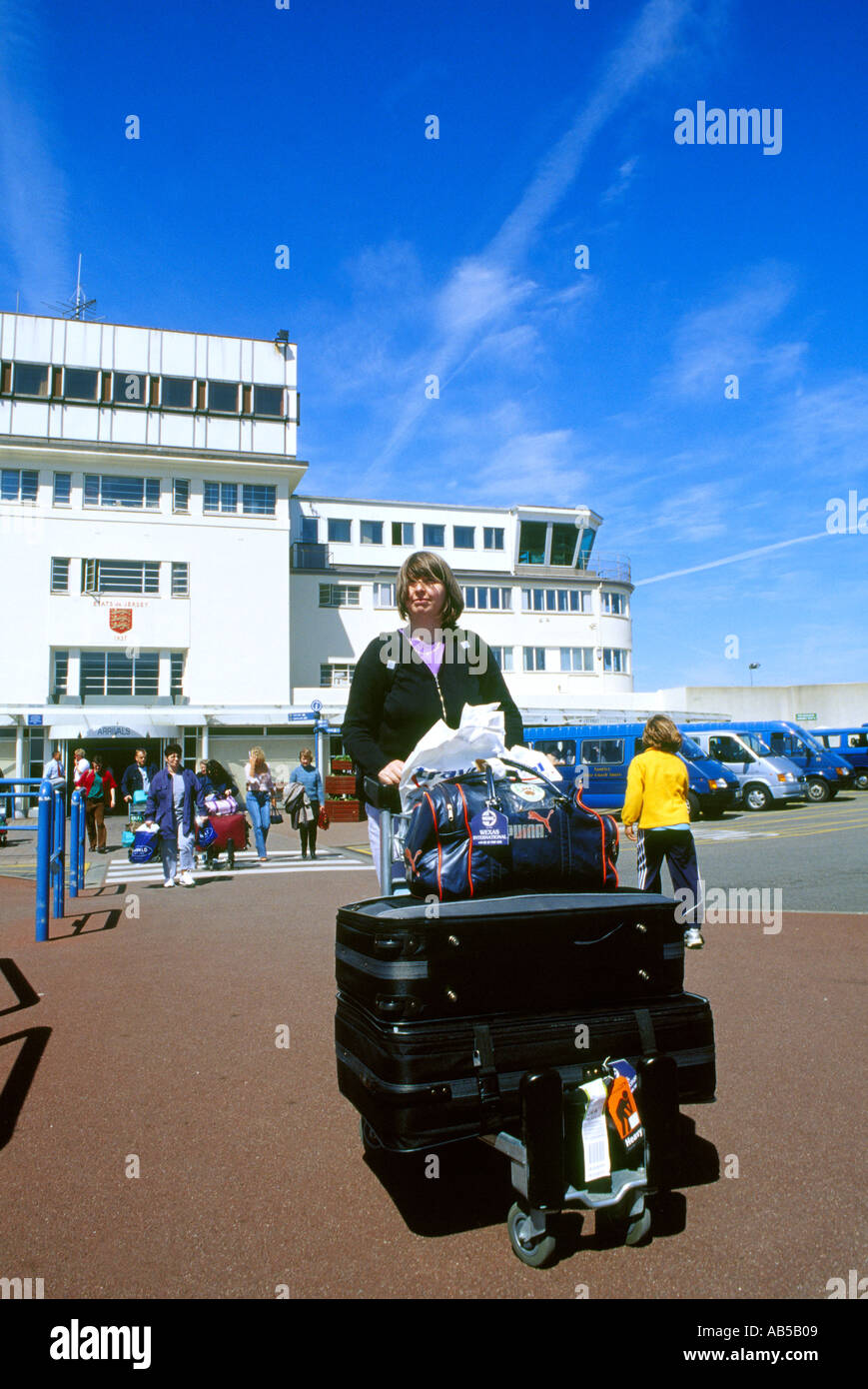 Female passenger arrived at Jersey Airport UK pushing trolley laden ...