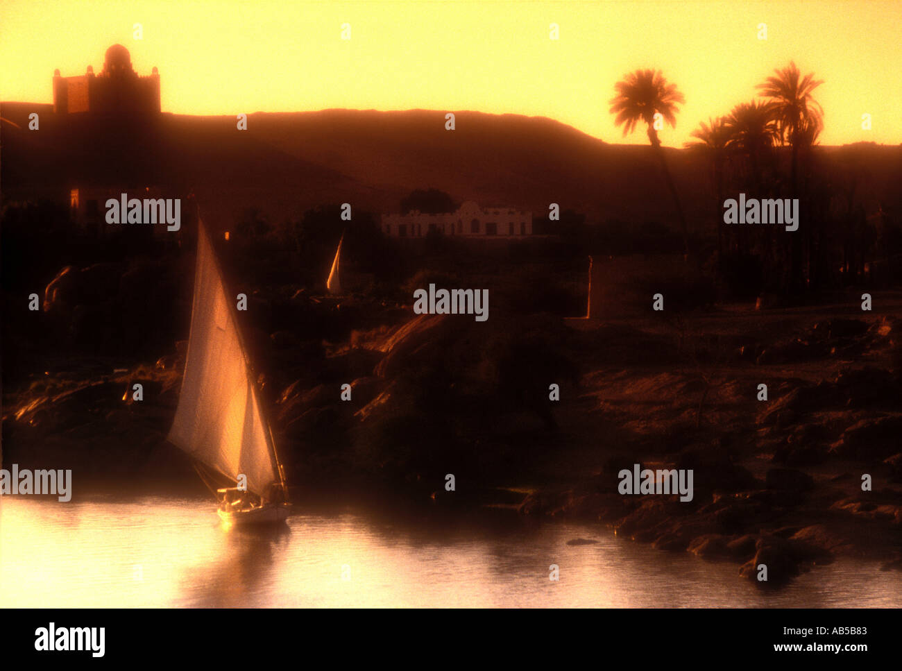 A felucca sailing on the River Nile at sunset at Aswan Egypt Stock ...