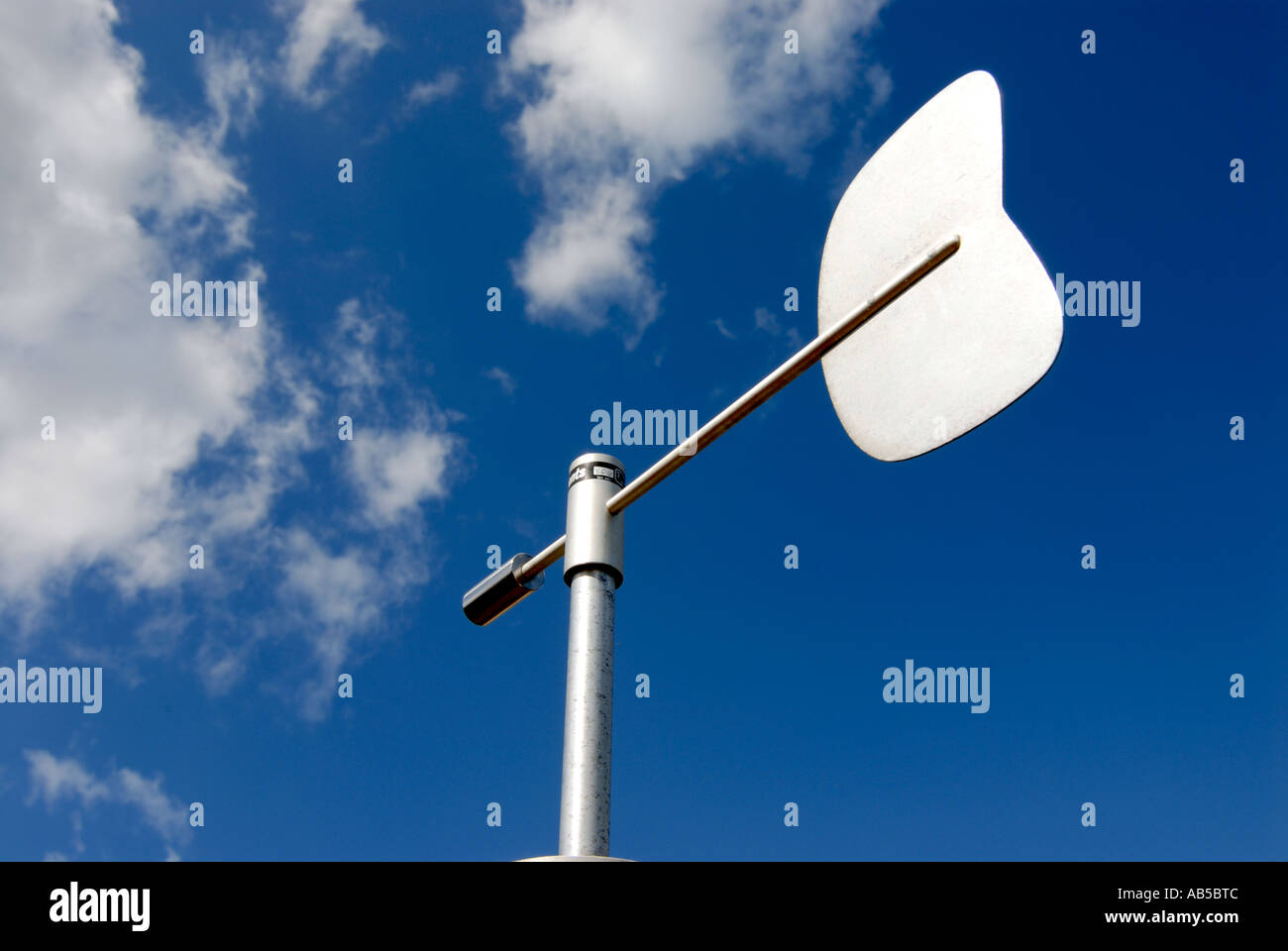A wind vane, used to indicate wind direction, seen against a deep blue ...