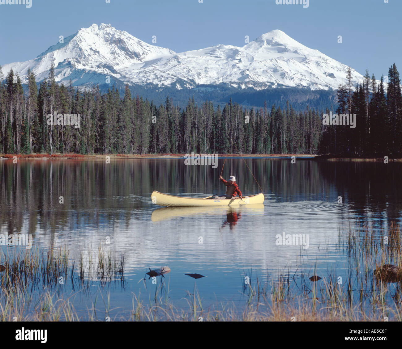 Fly fishing from a canoe at Scott Lake in the Sisters mountains area of ...