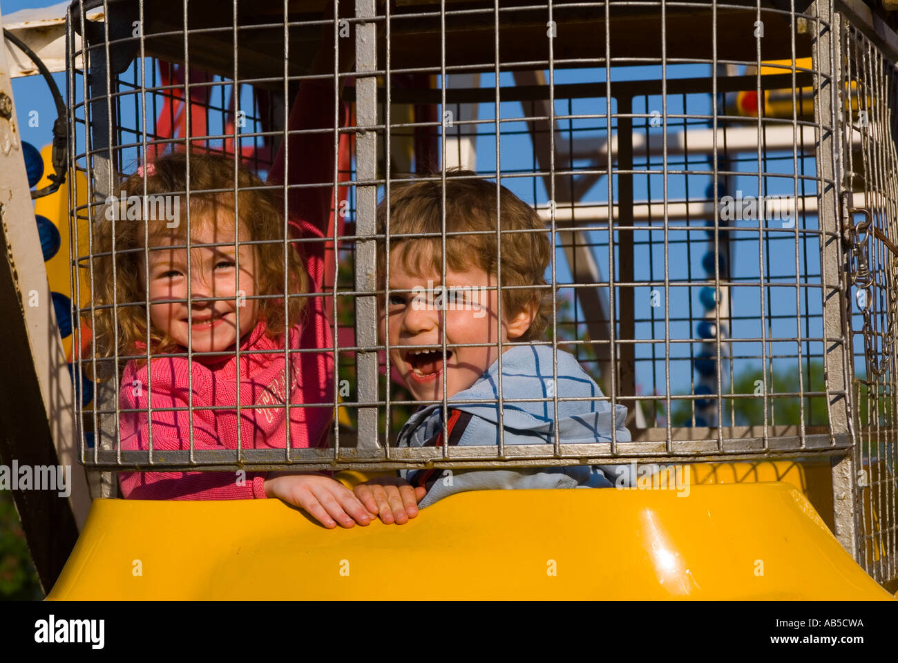 2 young children having fun on fairground ride Stock Photo - Alamy