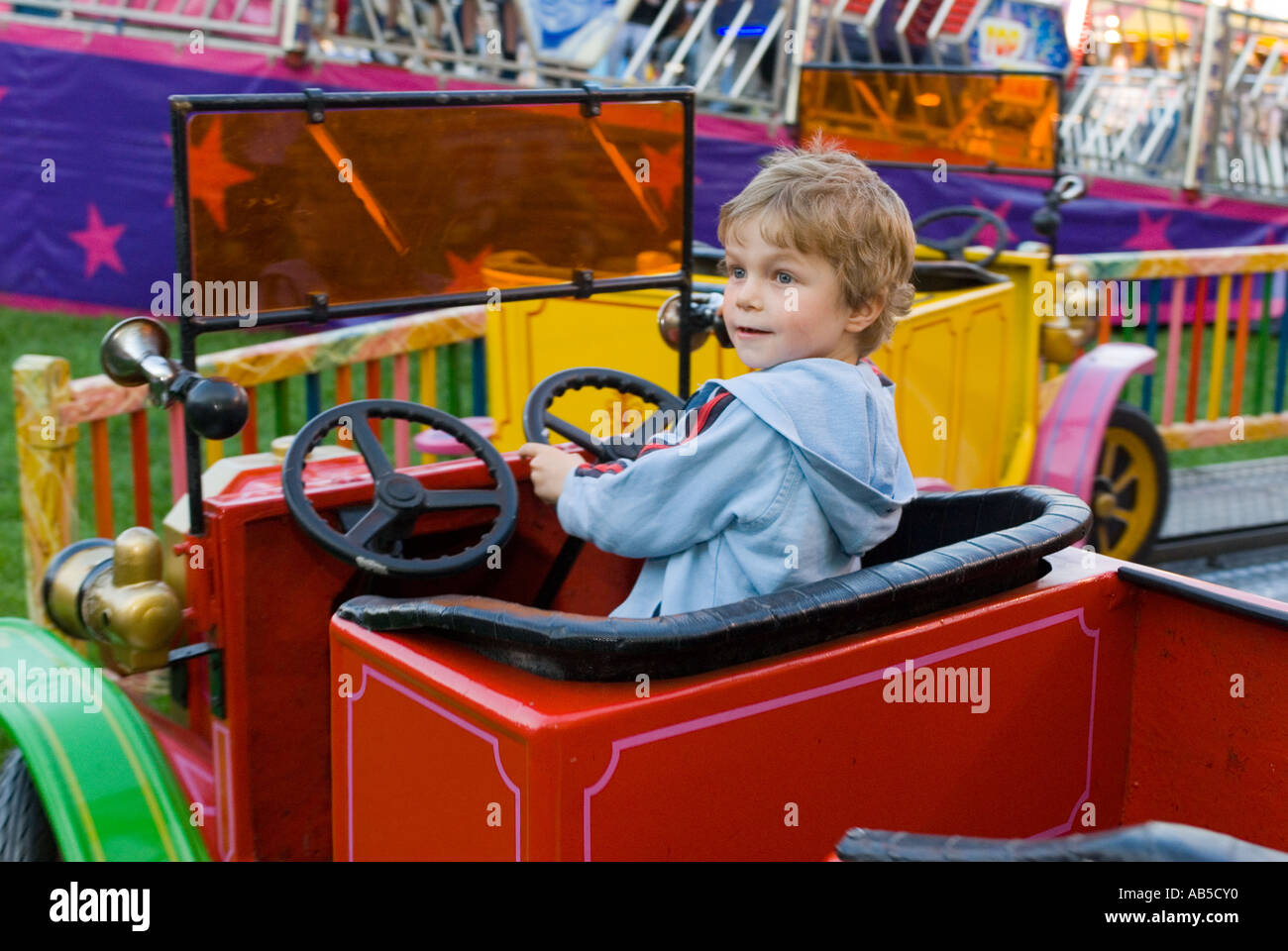 Young child having fun on fairground ride Stock Photo - Alamy