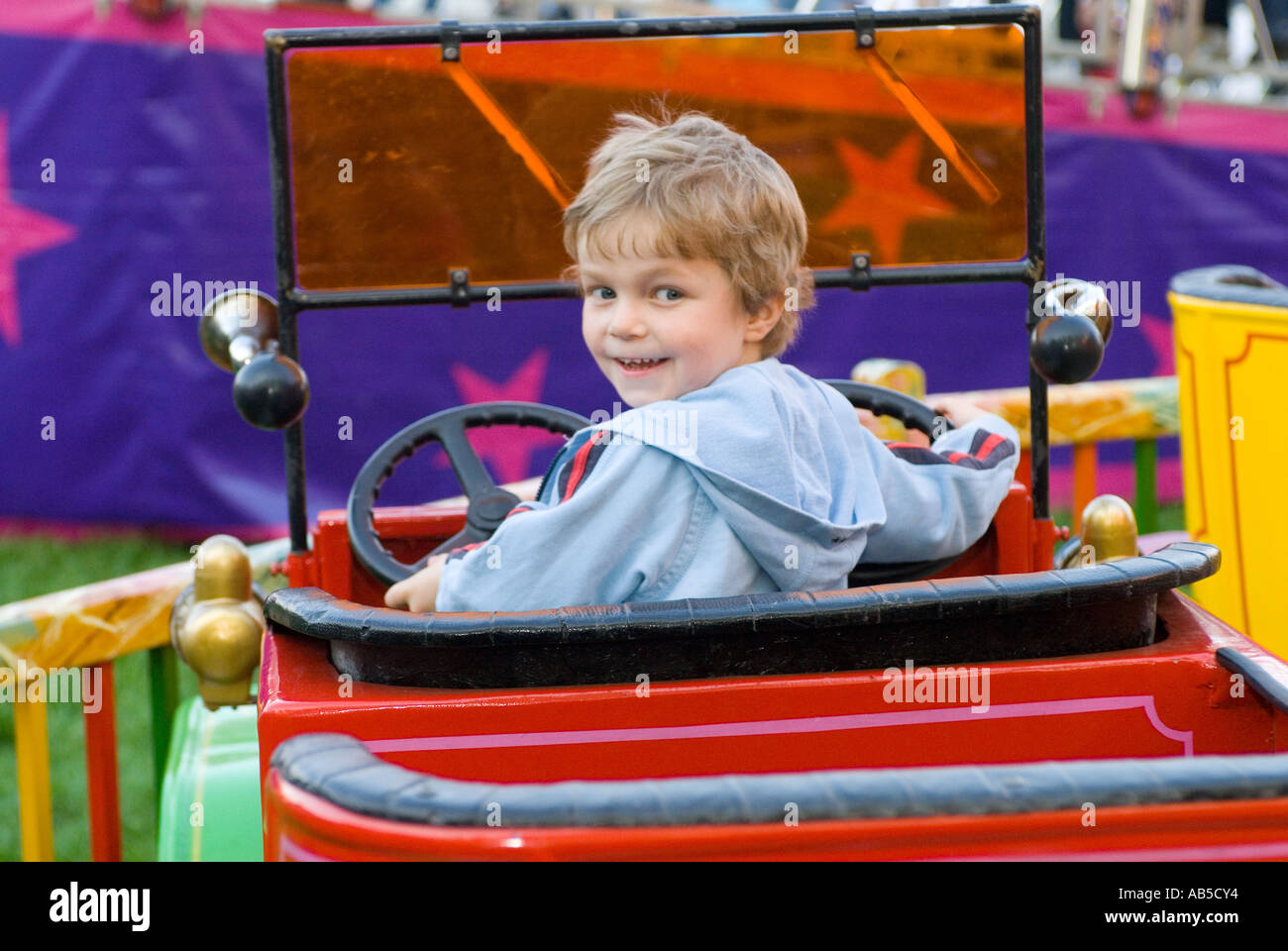 Young child having fun on fairground ride Stock Photo - Alamy