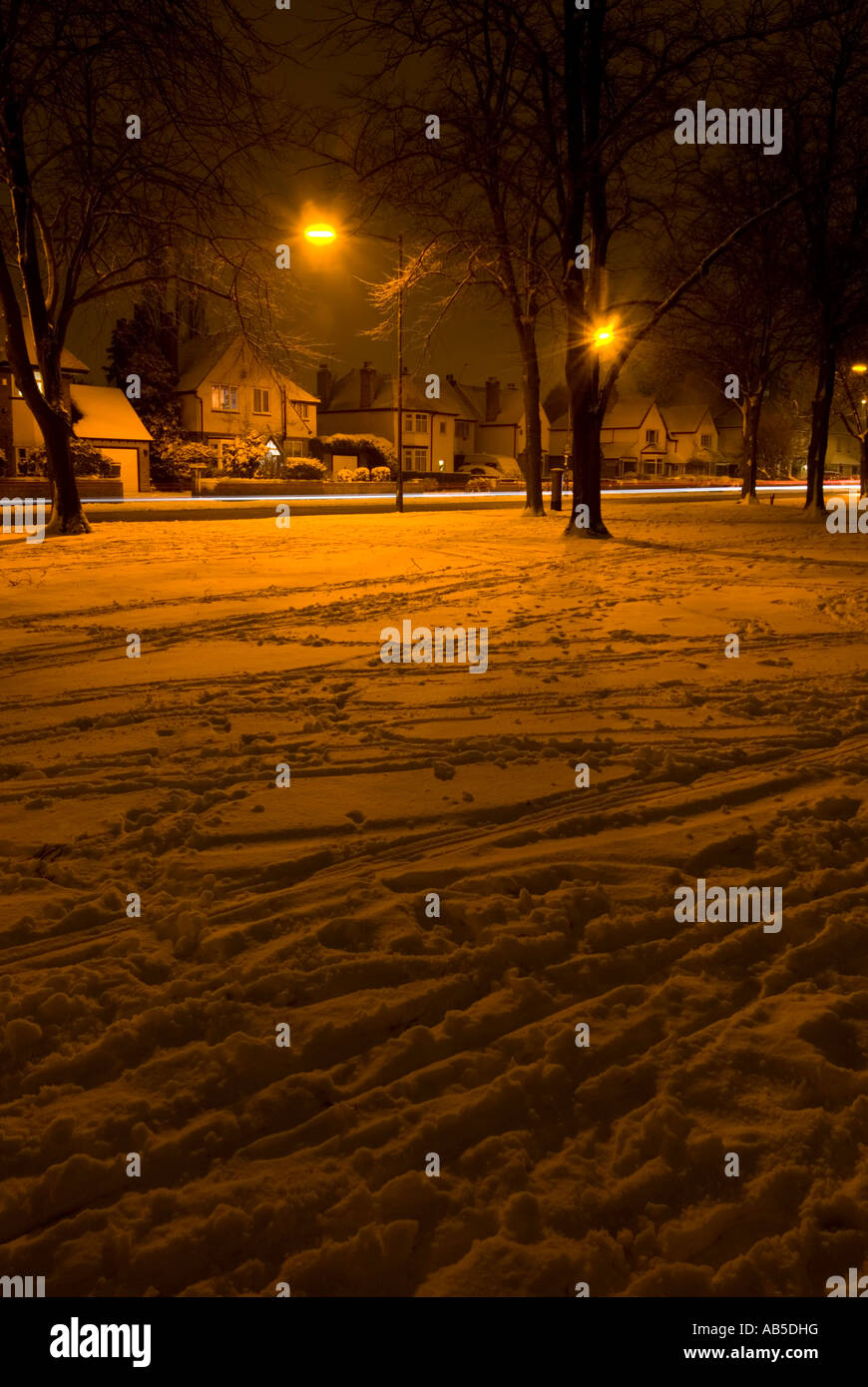 a night scene in an urban street in birmingham with snow fall on the ...
