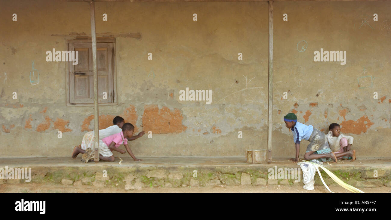 Children play a game similar to marbles with small stones near the ...