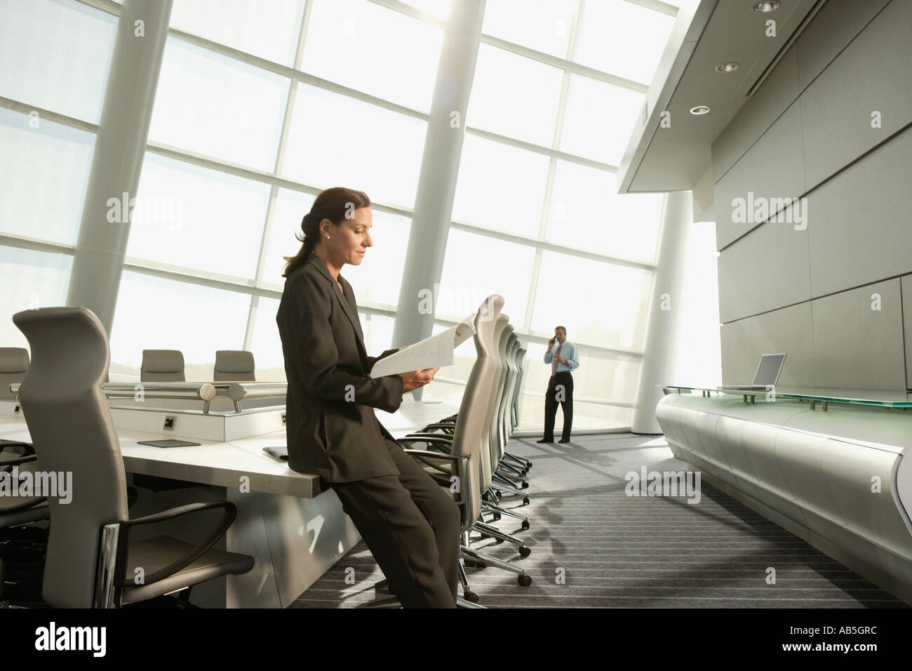 Businesswoman reading paperwork in conference room Stock Photo - Alamy