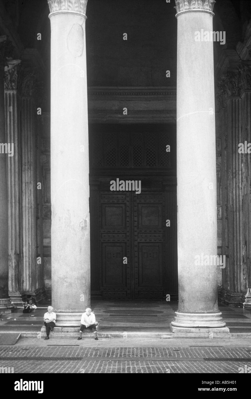 People sitting against a column Stock Photo - Alamy