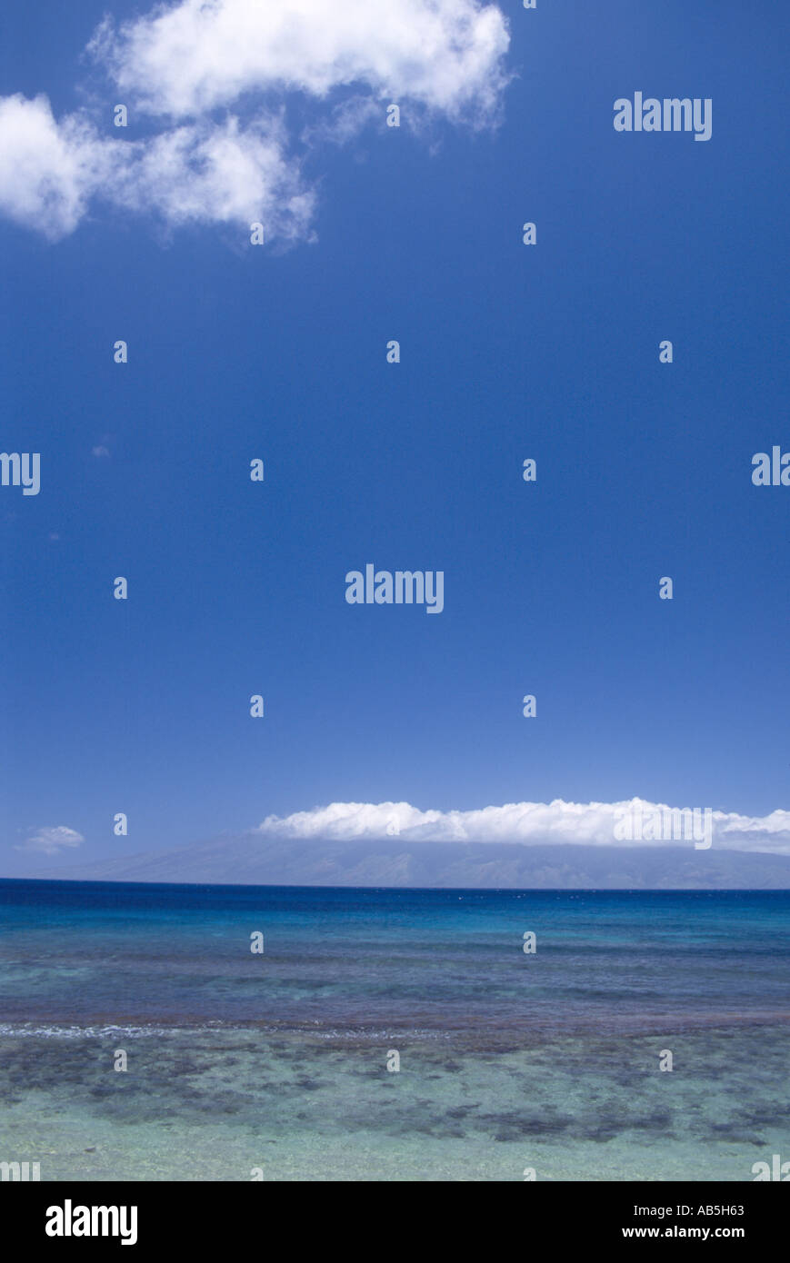 coral reef coral heads sea clouds blue sky Molokai in background Kahana ...