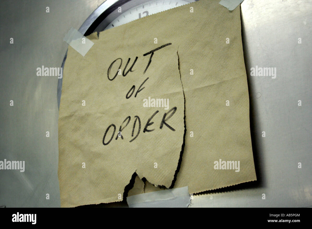torn paper sign over broken clock saying out of order in hospital ...