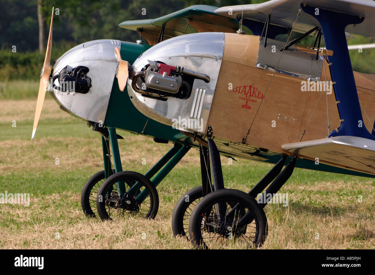 Two old style biplanes in a grass field. The aircraft are called ...