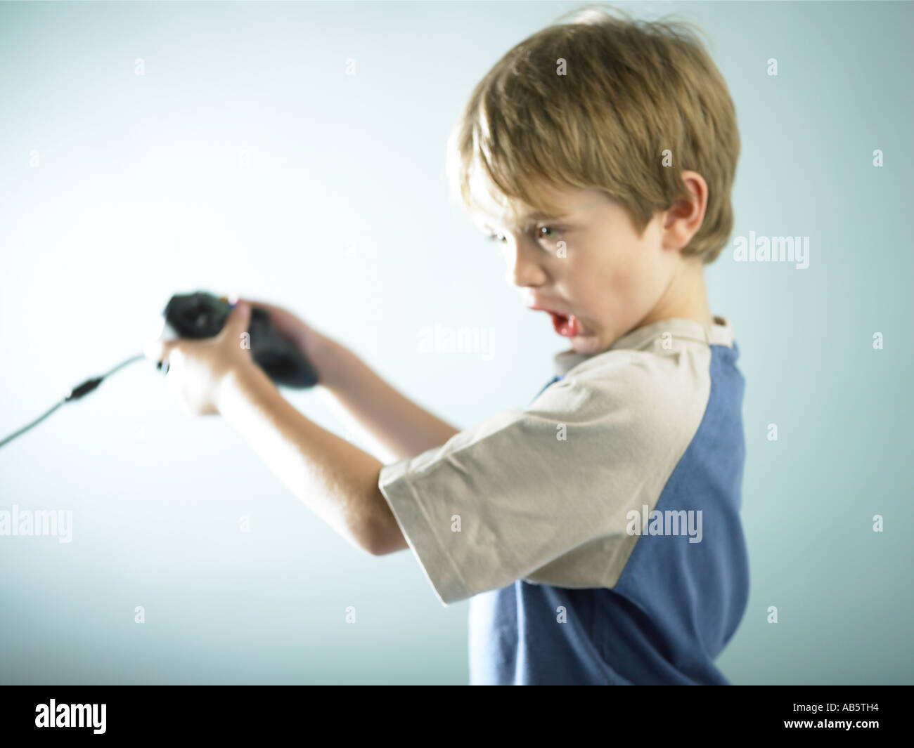 boy 6yrs excited playing on game console moving around in excitement ...