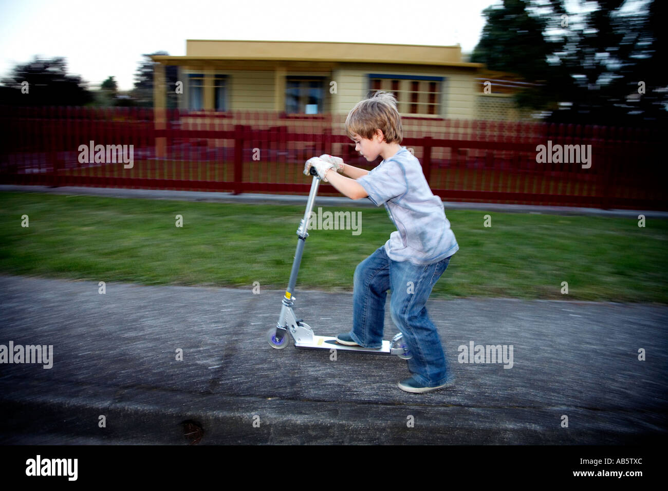 boy 5yrs riding on pavement on scooter Stock Photo - Alamy