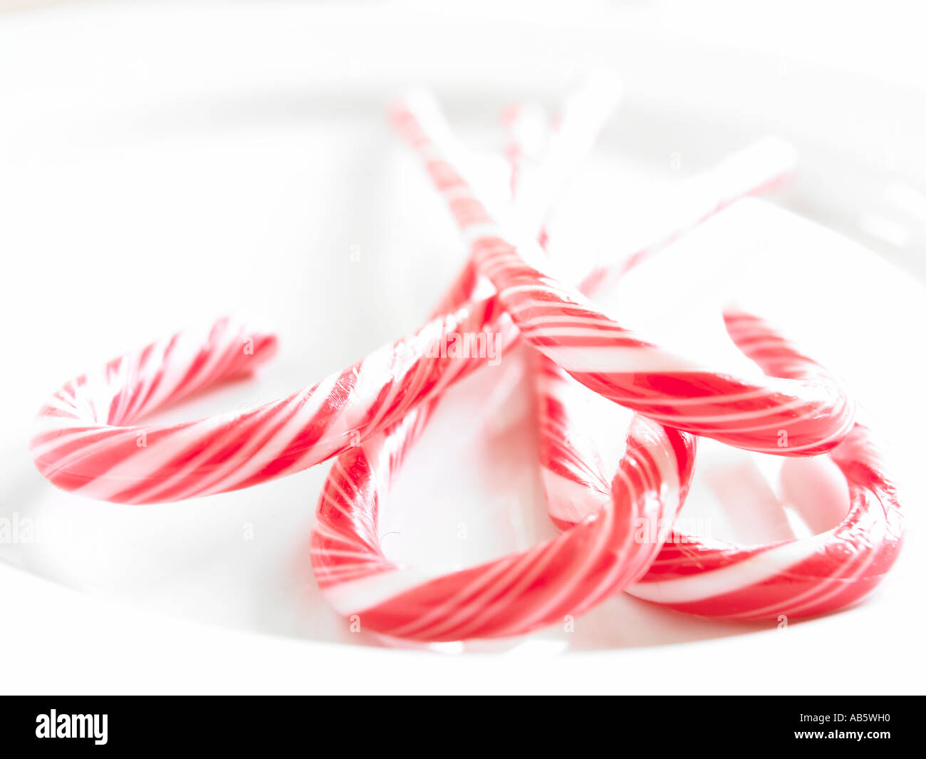 four red and white candy cane layed down crossing each other on top of ...