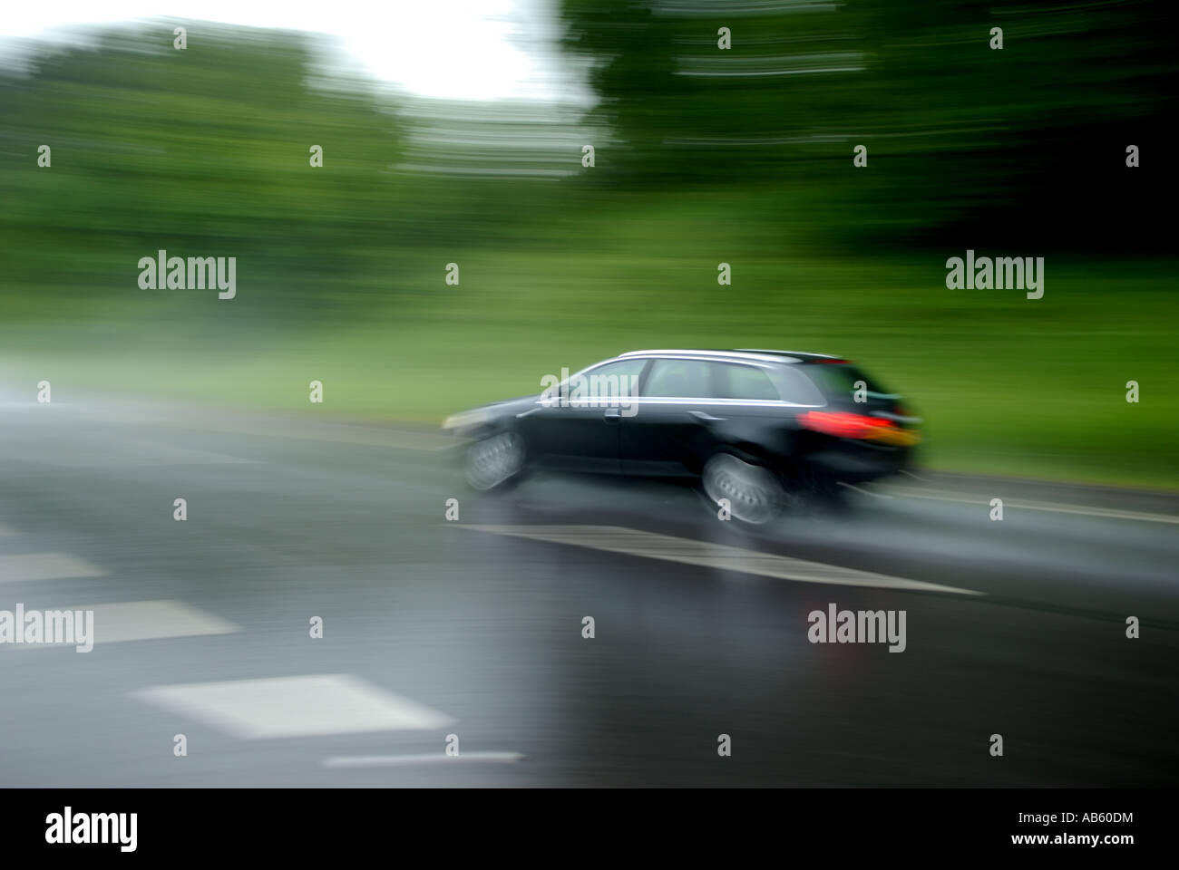 Blured car on wet road surface Stock Photo - Alamy