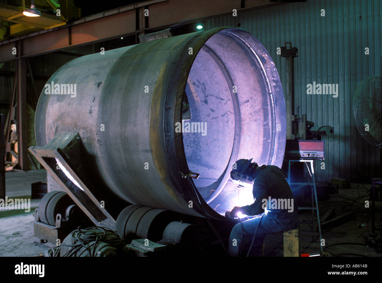 Welder welding inside large metal valve Stock Photo - Alamy