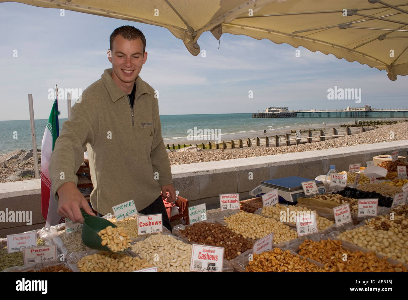 Man serving at nut stall in worthing,west sussex on a sunny day ...