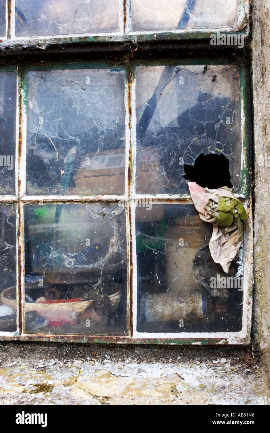 An old, rusty window frame with a broken window and peeling paint Stock ...