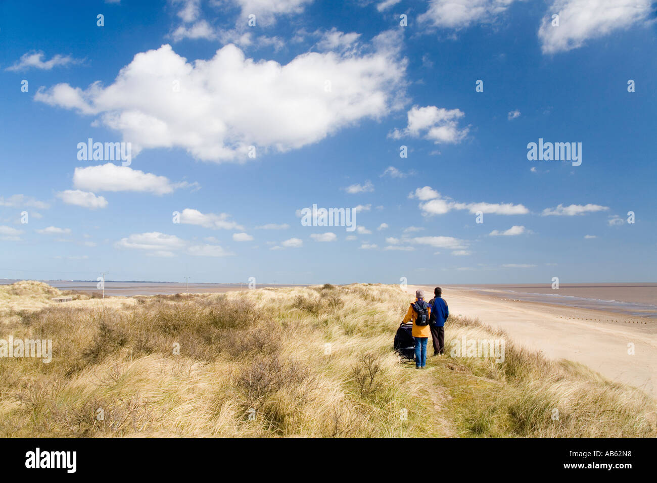 Two people walking on the dunes at Spurn Head on a bright sunny day ...