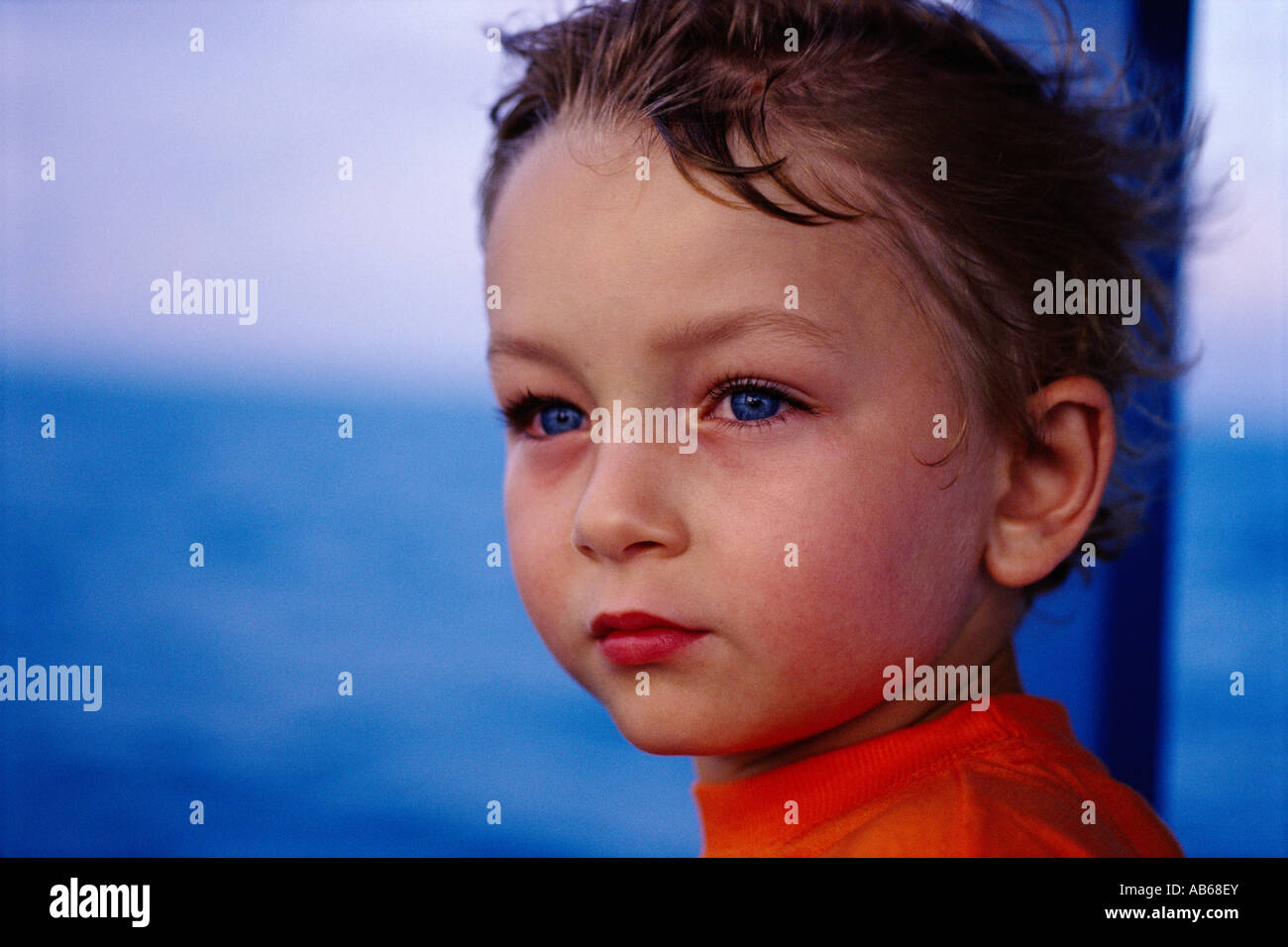 Portrait of a boy 4-6 years on a boat looking into the distance at ...