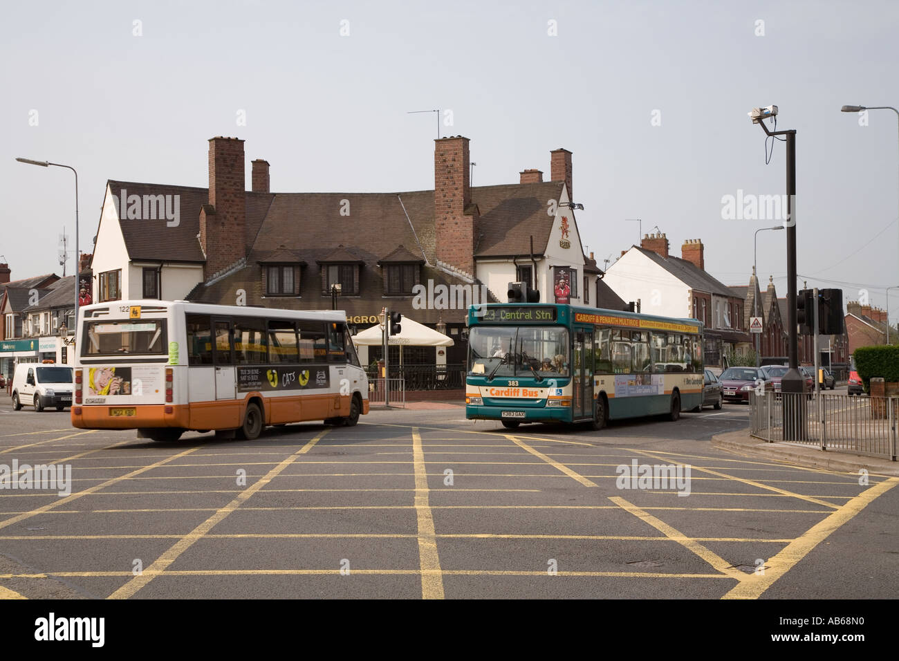 Two buses at a busy crossroad intersection with yellow do not enter box ...