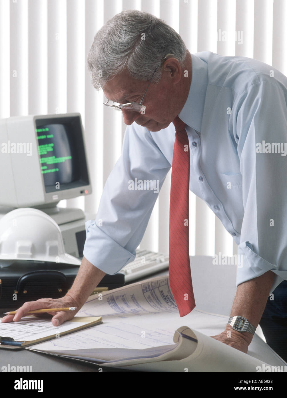 mature male business executive studying architectural drawings in ...