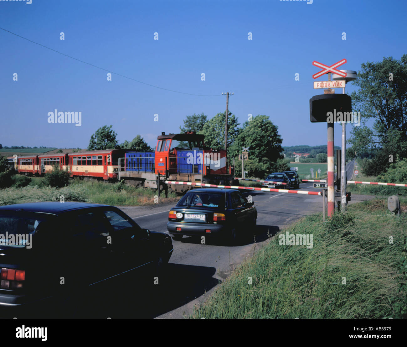 Small passenger train crossing a rural level crossing, northern Czech ...