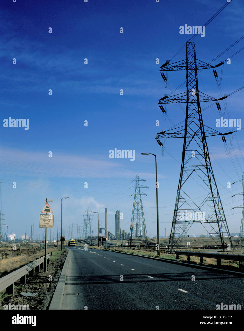 Electricity pylons in an industrial landscape, with road stretching ...