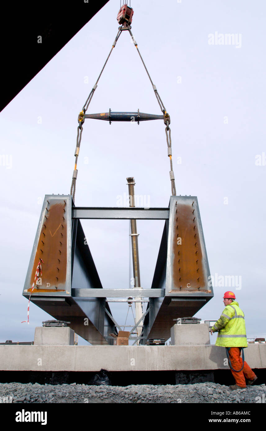 Construction worker positioning large steel structure. © Copyright ...
