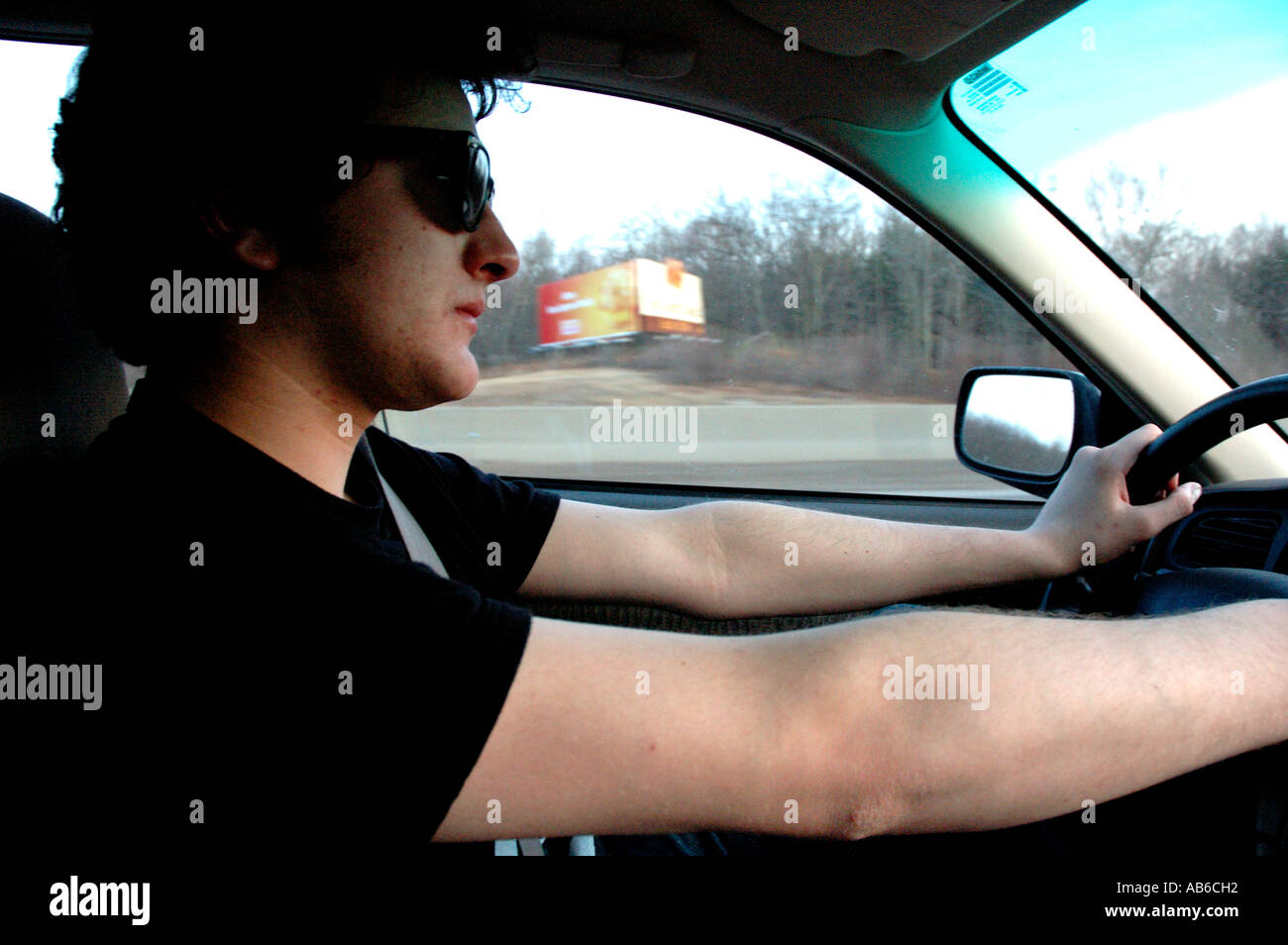 Young lad driving car with dark glasses Stock Photo - Alamy