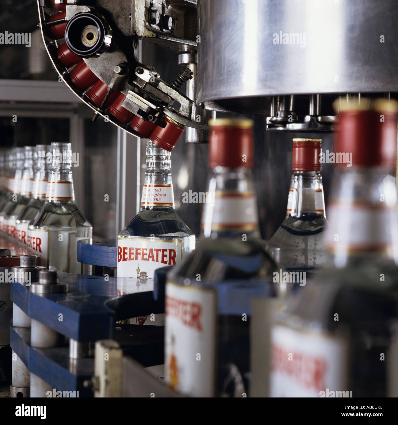 Production line for Beefeater gin showing aluminium bottle caps being ...