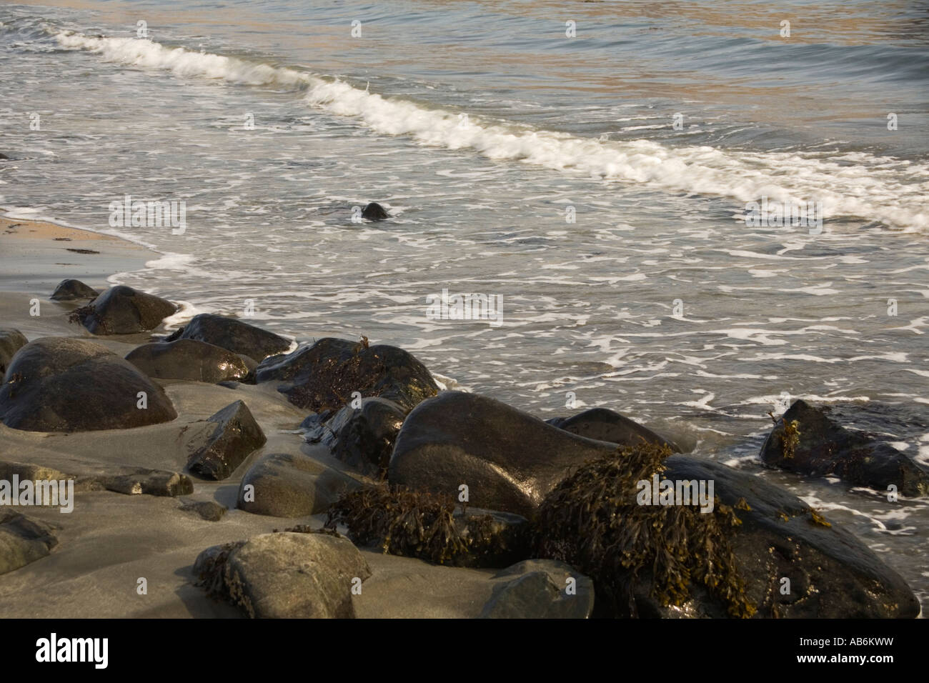 Incoming tide on rocky beach Stock Photo - Alamy