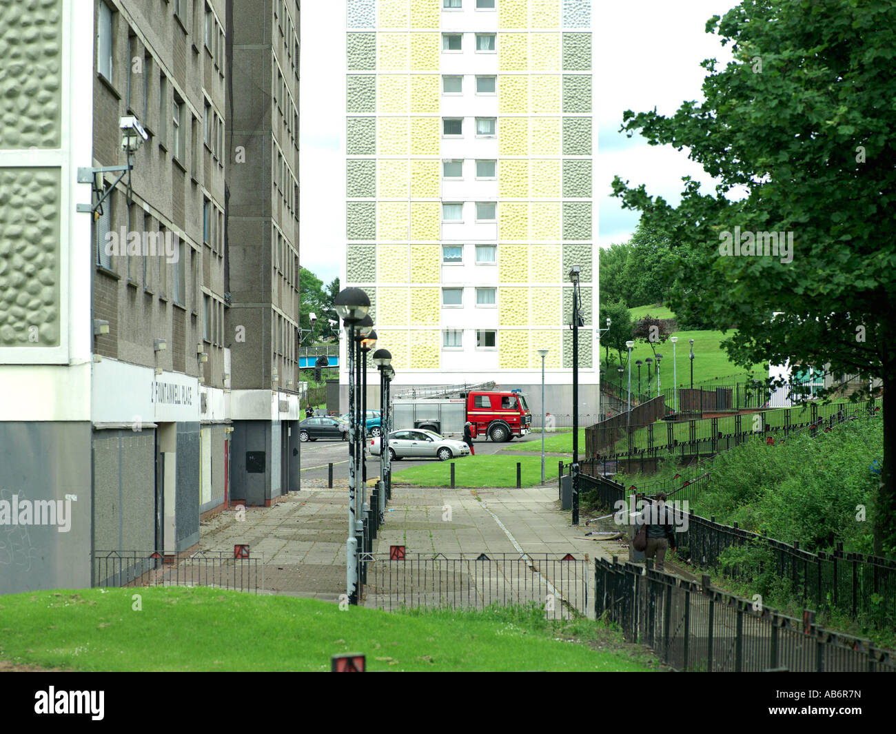 Path way through high rise flats with fire engine in the background ...